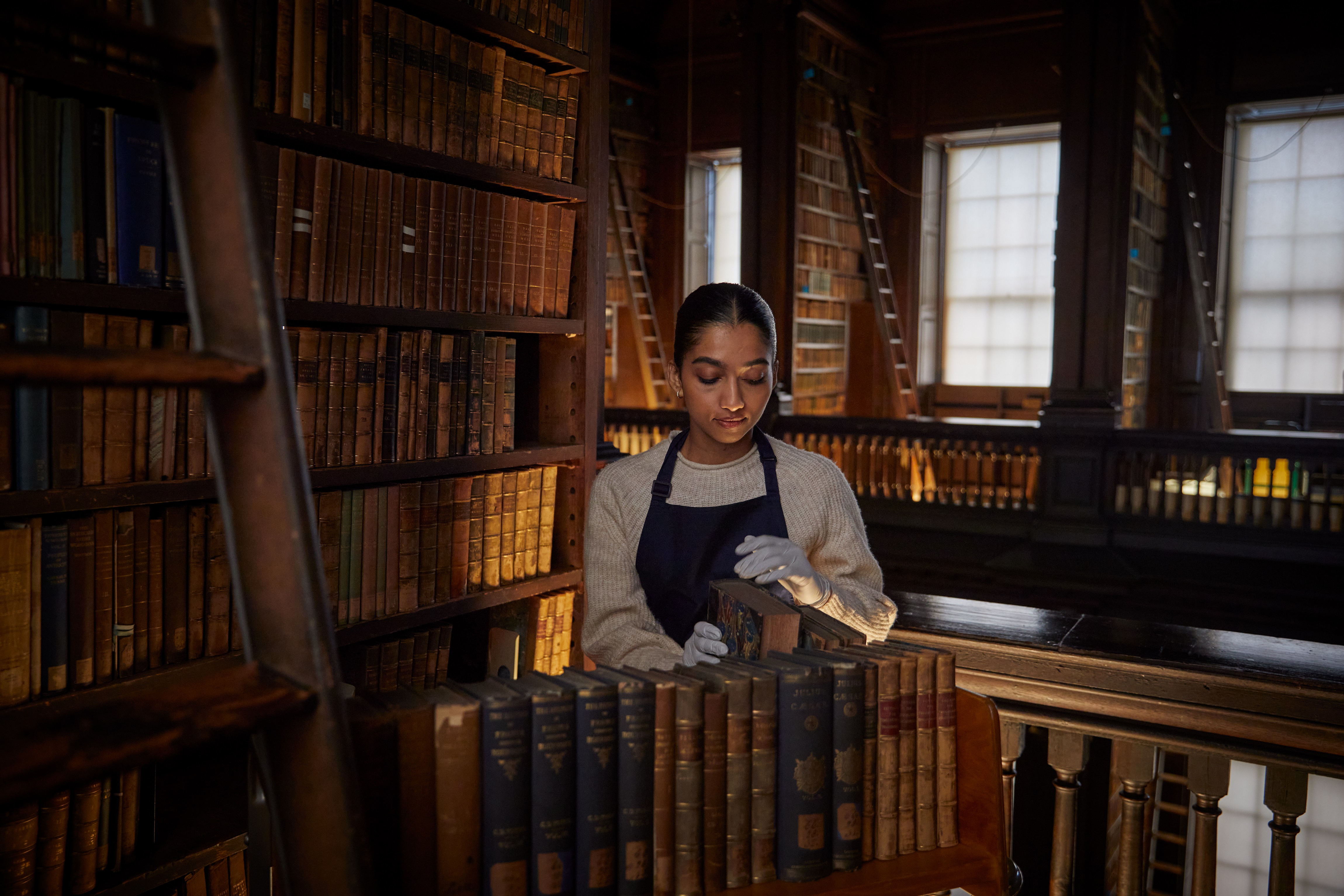Why have books been removed from Trinity College Library?